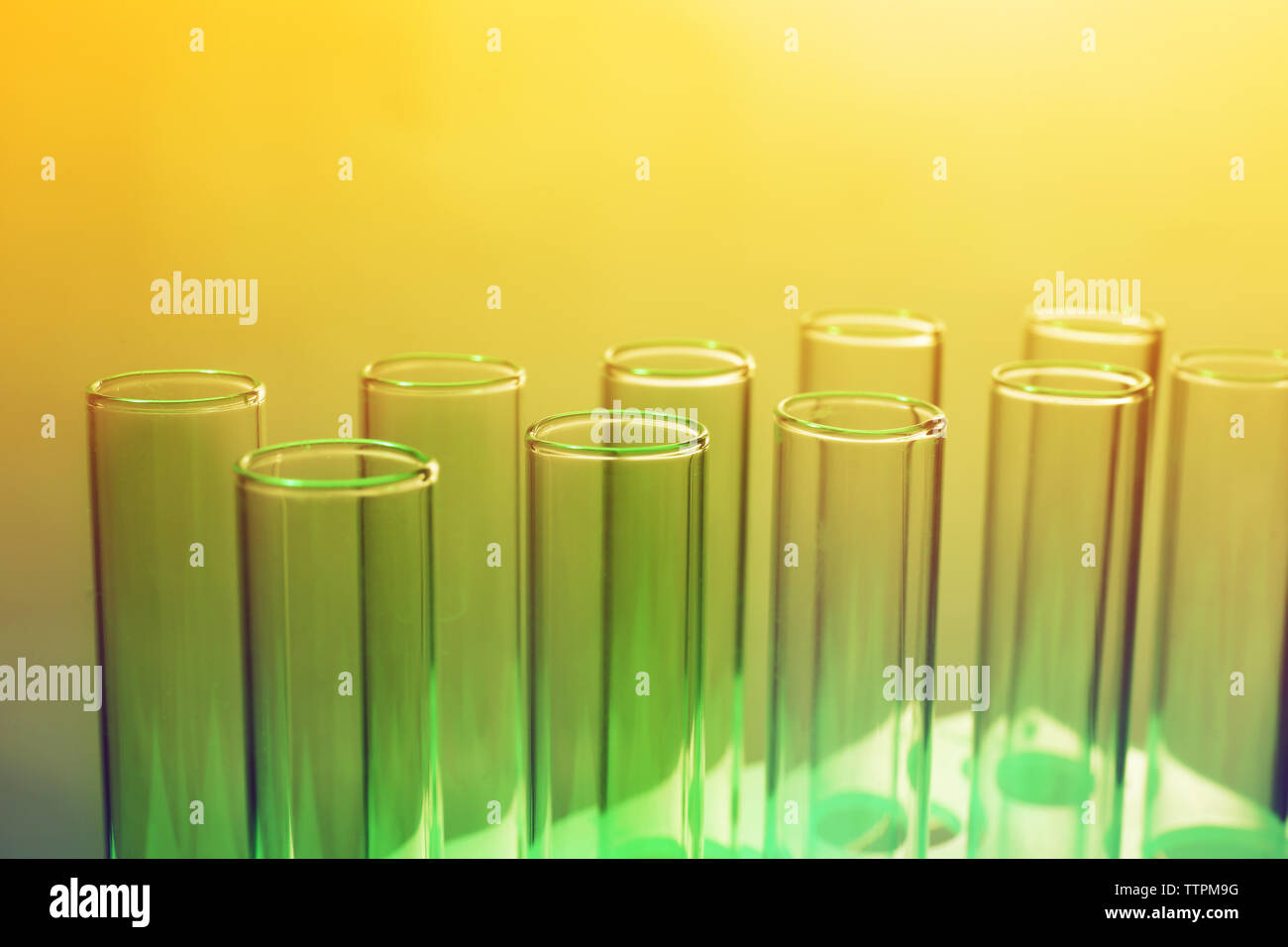 Test tubes on light yellow background Stock Photo - Alamy
