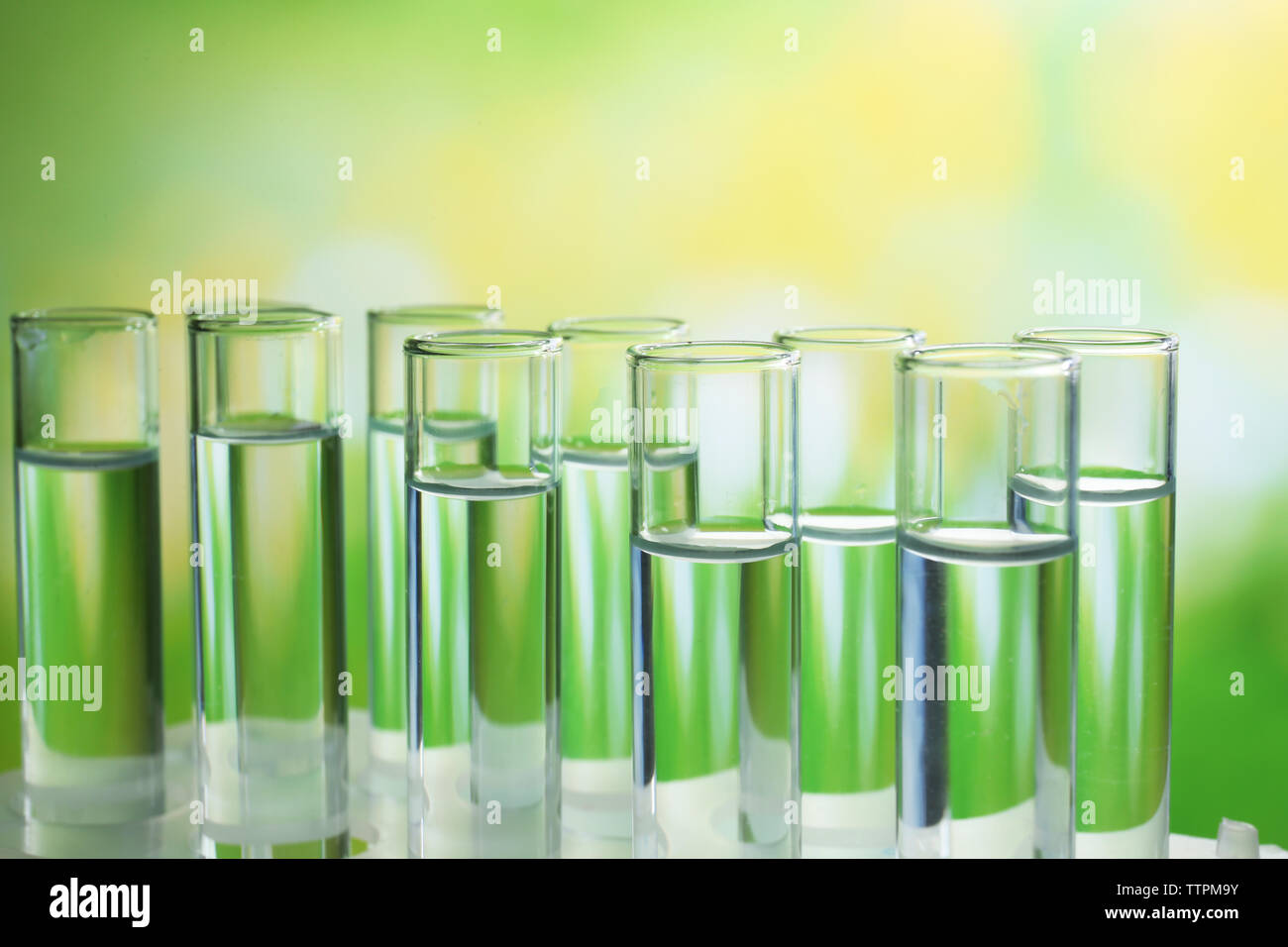 Test tubes on light green background Stock Photo - Alamy