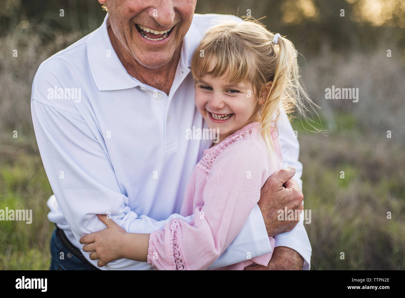 Grandfather hugging young granddaughter and laughing Stock Photo - Alamy