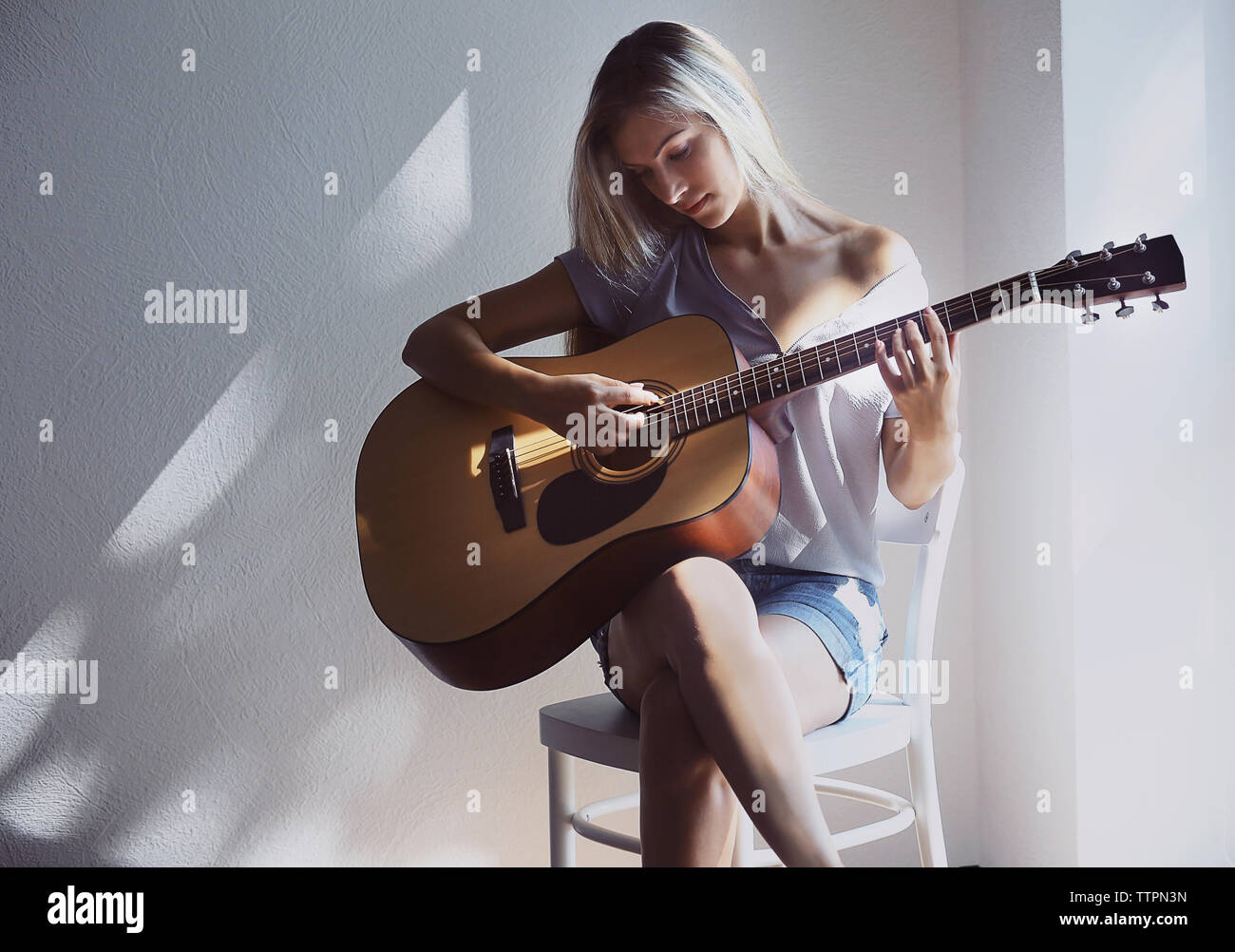 Beautiful woman playing guitar Stock Photo - Alamy