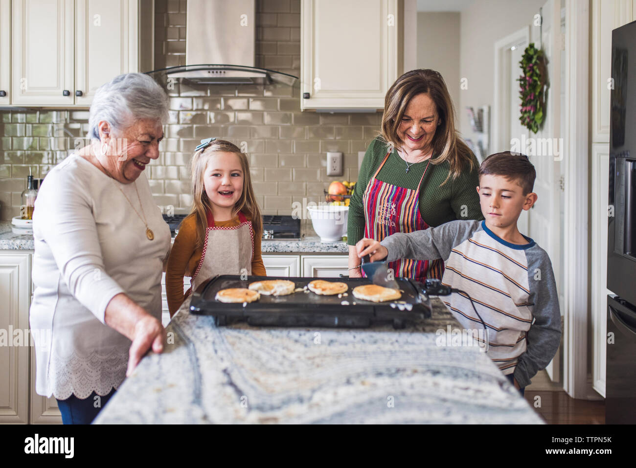 Lifestyle image of young girl and boy making breakfast Stock Photo - Alamy