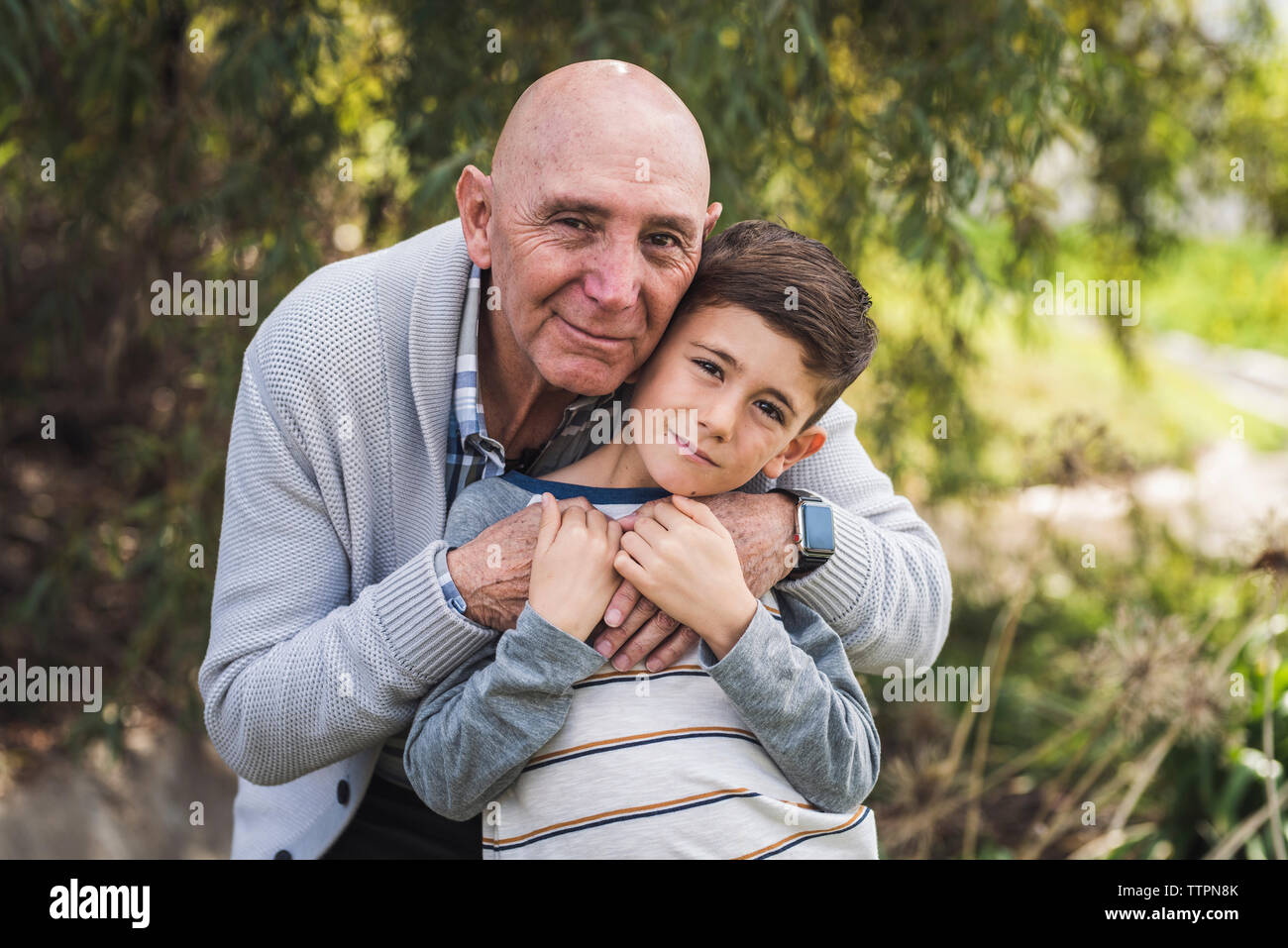 Children hugging grandfather hi-res stock photography and images - Alamy
