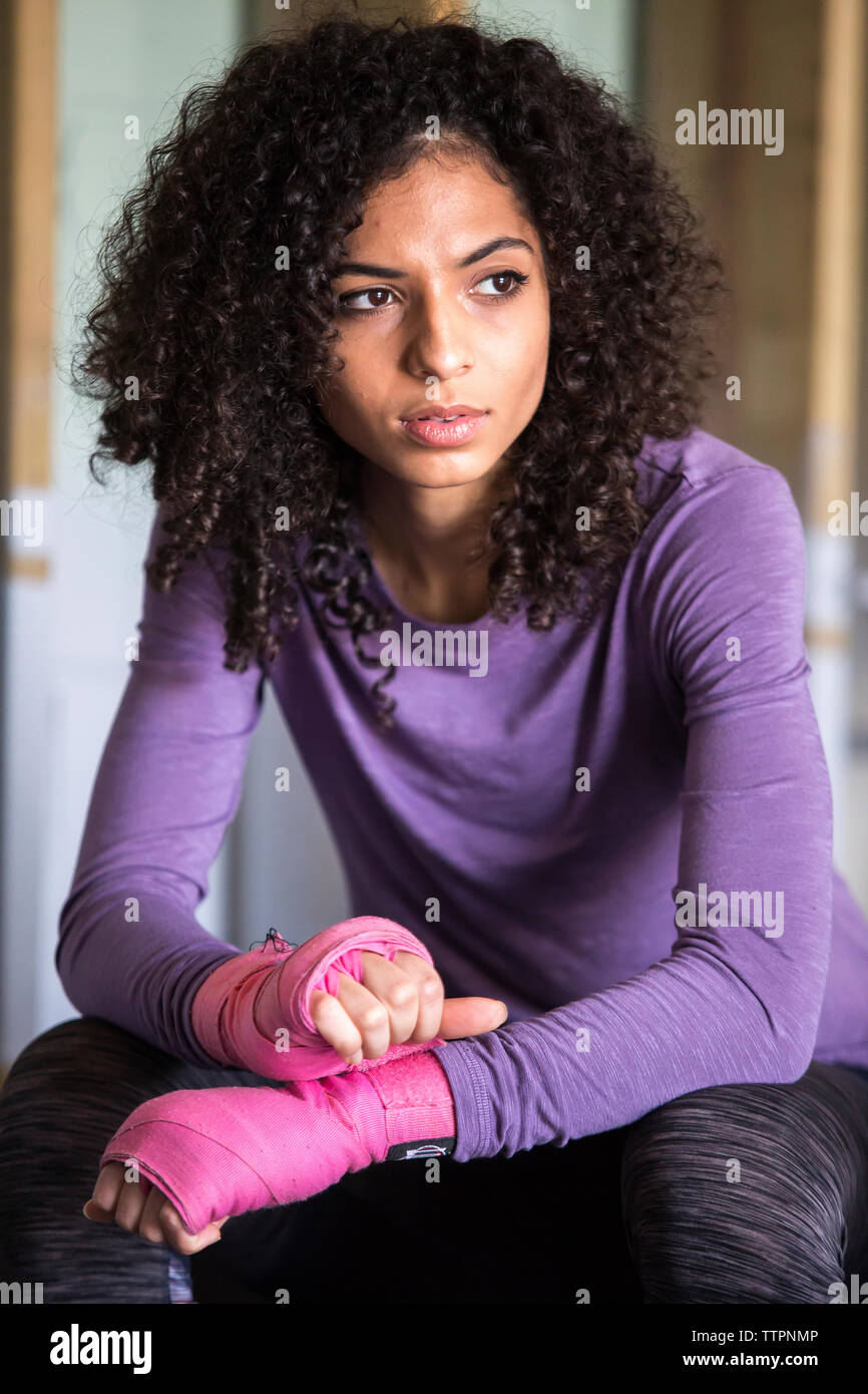 Female boxer looking away while sitting in gym Stock Photo - Alamy
