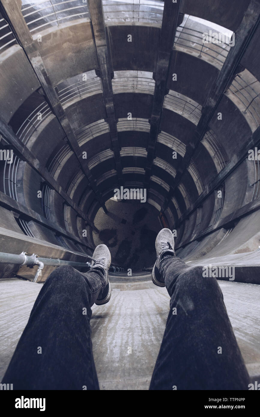 Low section of man sitting on building railing Stock Photo - Alamy