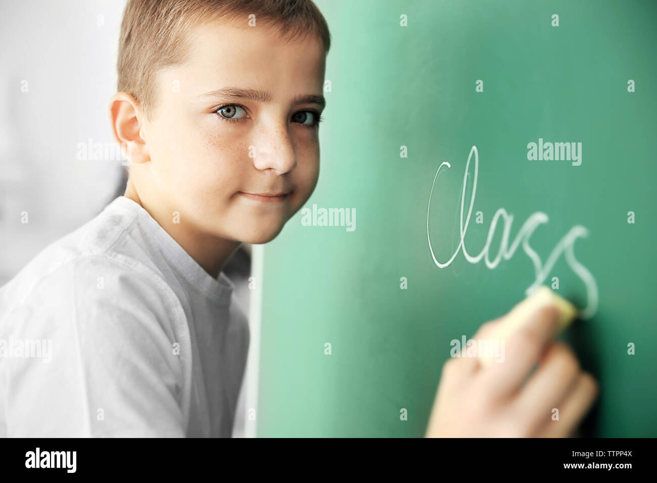 Cute schoolboy writing on chalkboard Stock Photo - Alamy