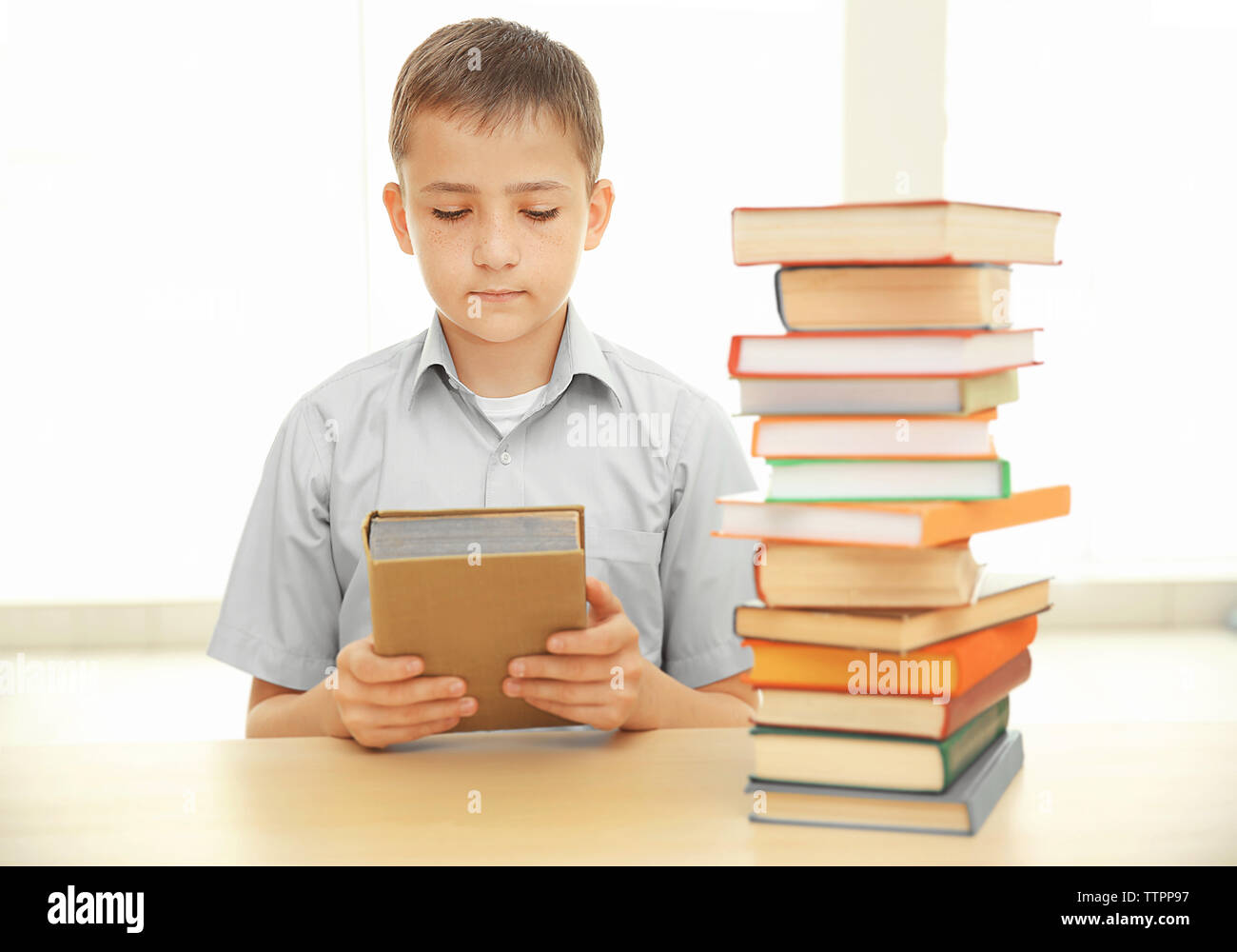 Boy with many books at school Stock Photo - Alamy