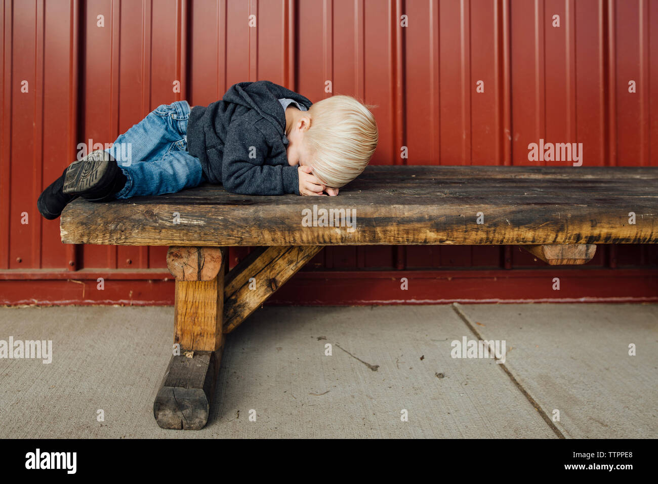 Boy lying down on bench hi-res stock photography and images - Alamy