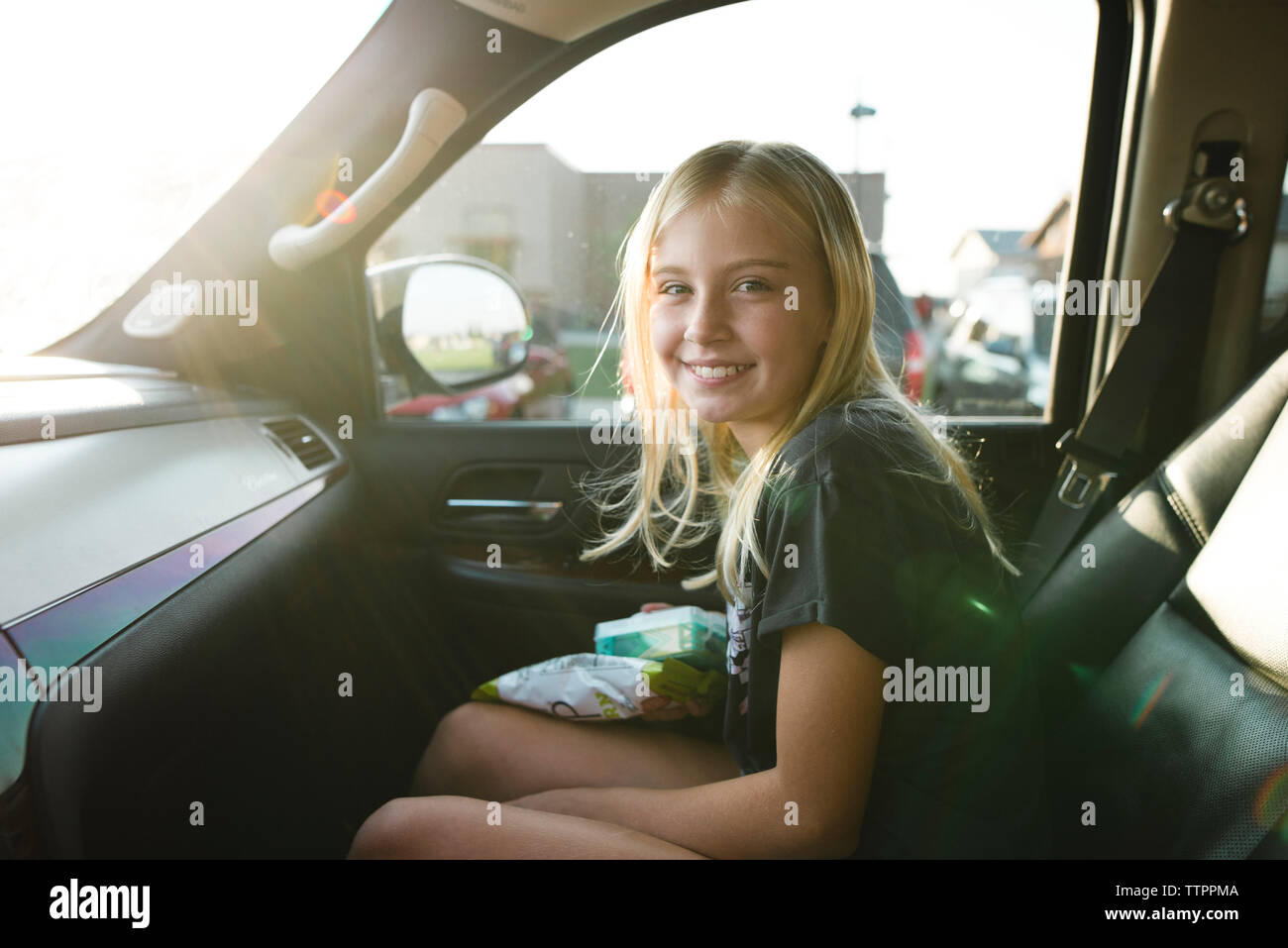 Portrait of smiling girl sitting in car Stock Photo - Alamy