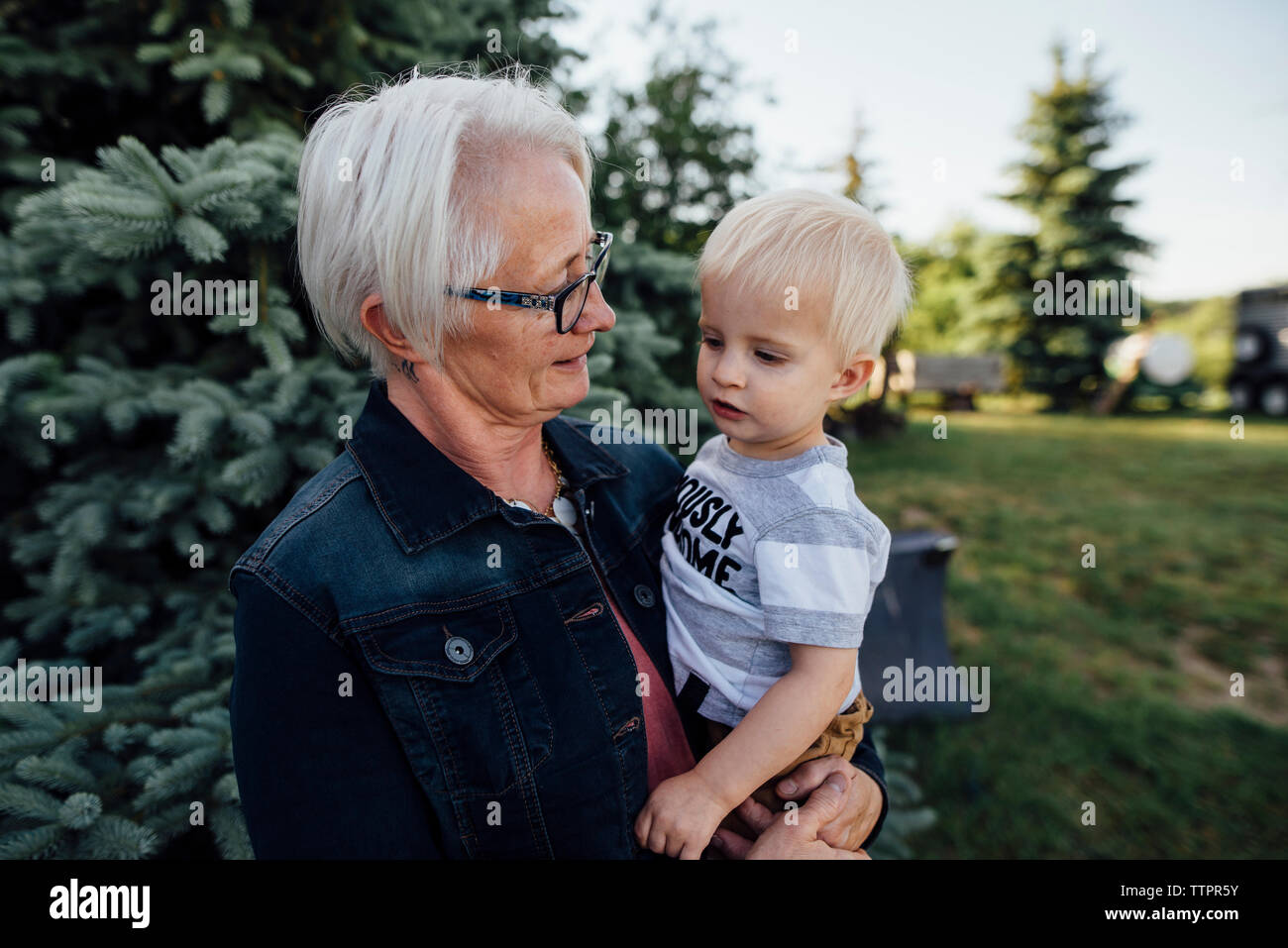 Grandmother carrying grandson while standing at farm Stock Photo - Alamy
