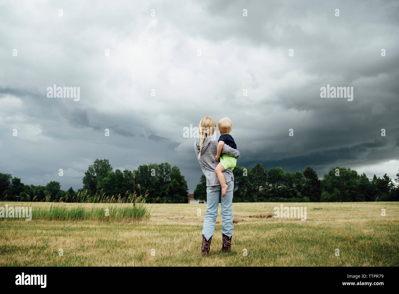 Girl carrying baby brother sister hi-res stock photography and images ...