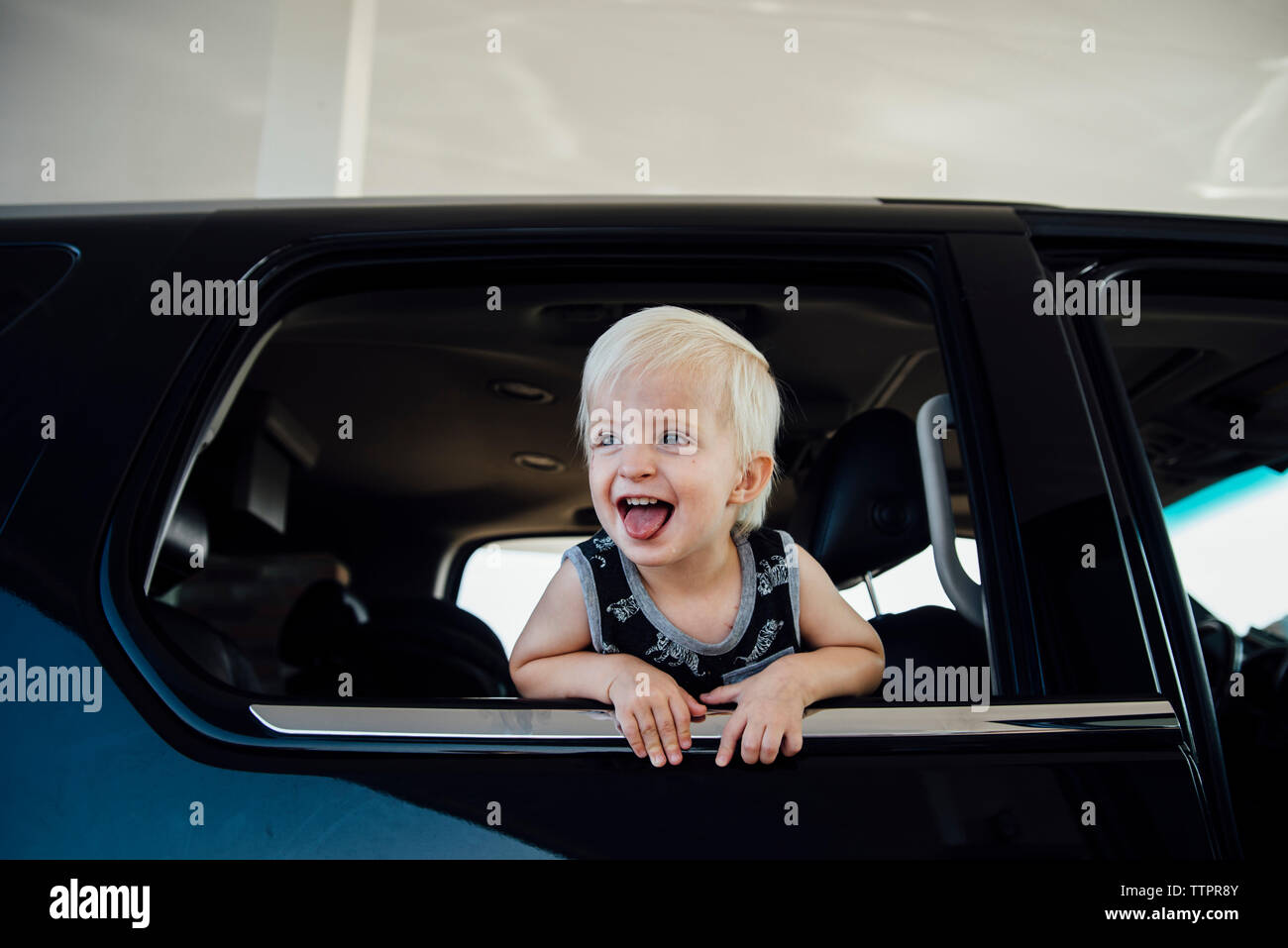 Happy baby boy looking through window while traveling in car Stock ...