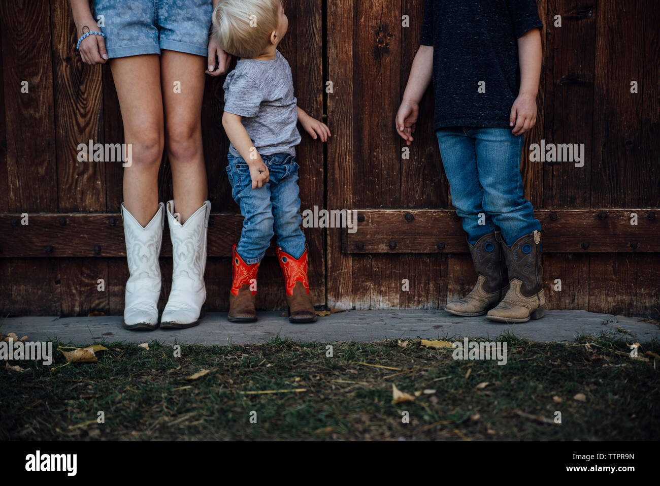 Siblings standing by wooden door Stock Photo - Alamy