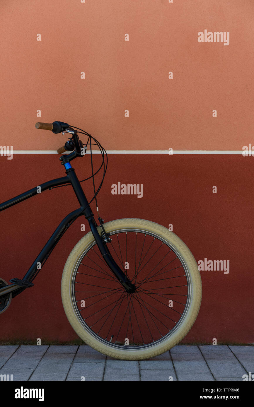 Bicycle parked by building on sidewalk in city Stock Photo - Alamy
