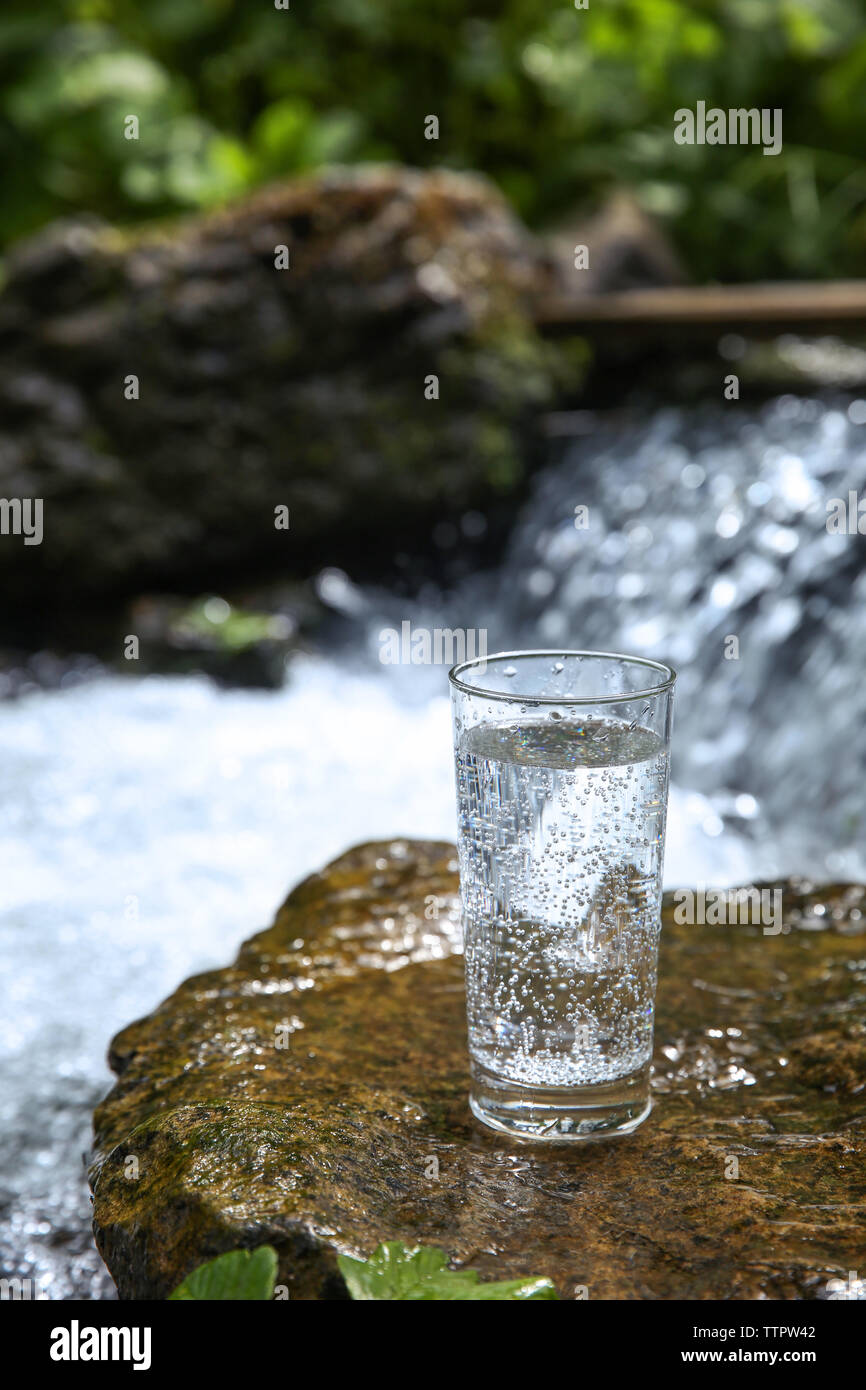 Cup of water on small waterfall background Stock Photo - Alamy