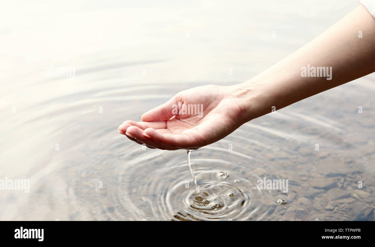 Woman pouring water in hand Stock Photo - Alamy