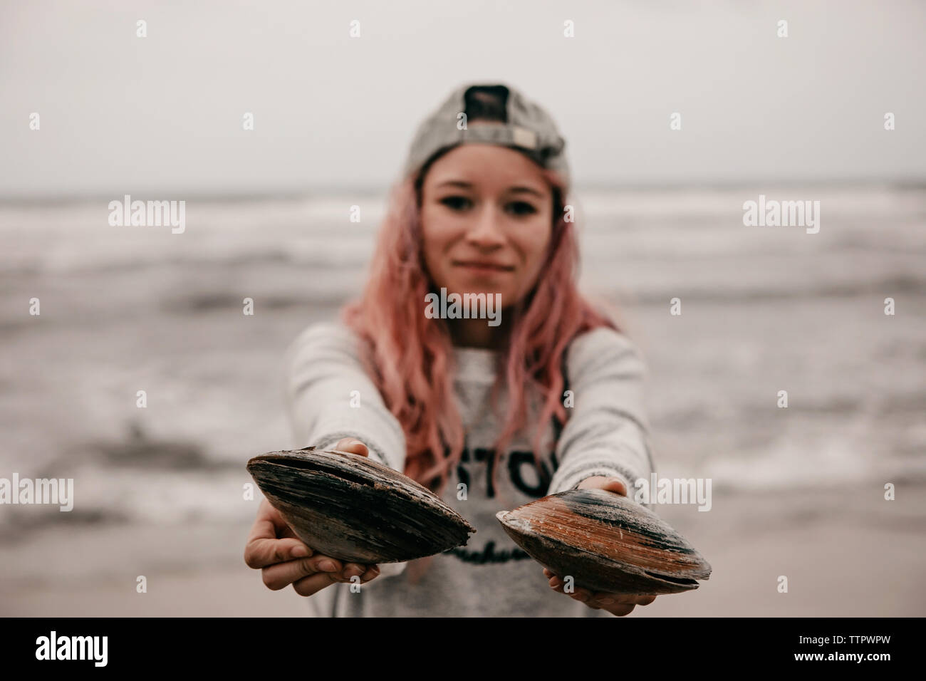 young woman holding shells on a beach Stock Photo - Alamy