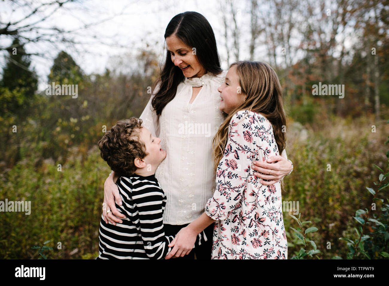 Happy siblings with mother at park Stock Photo - Alamy