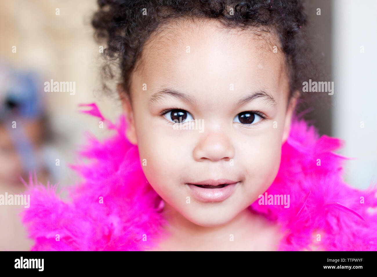 Portrait of cute girl with pink feather boa at home Stock Photo - Alamy