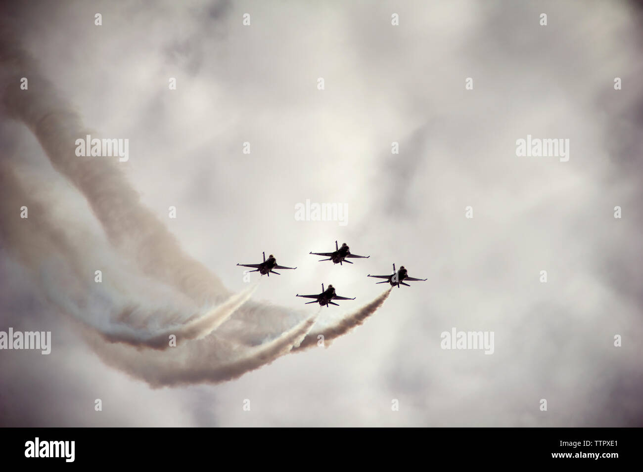 Low angle view of fighter planes flying during airshow in cloudy sky ...