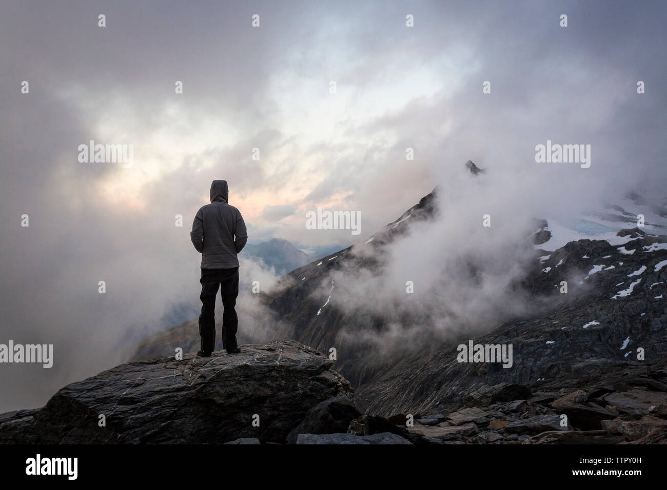 Figure overlooking a cloud covered mountain view in New Zealand Stock ...