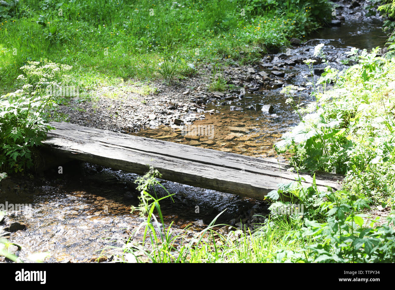 Wooden bridge across mountain river Stock Photo - Alamy