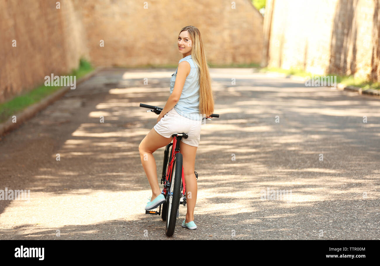 Beautiful girl riding bike on street Stock Photo - Alamy
