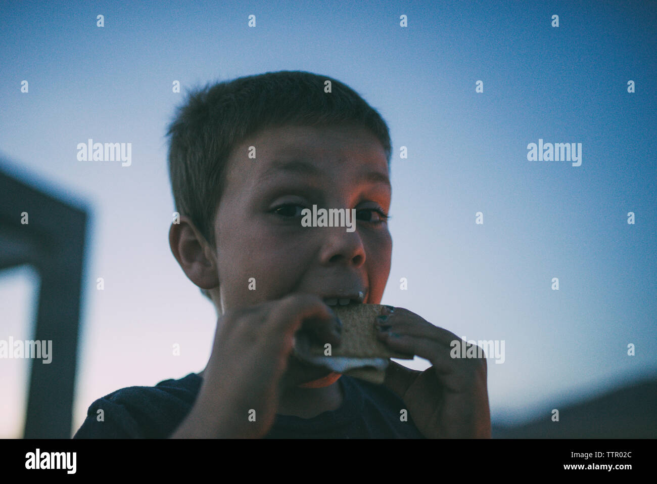 Close-up portrait of boy eating smore against sky at Joshua Tree ...