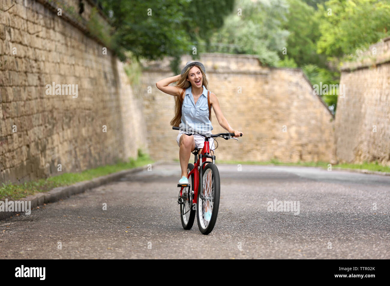Beautiful girl riding bike on street Stock Photo - Alamy