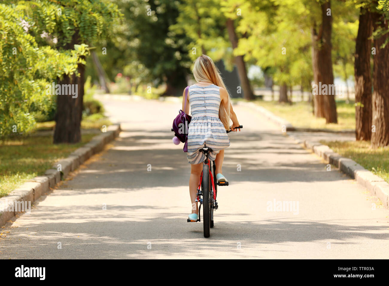 Girl riding bicycle on street Stock Photo - Alamy