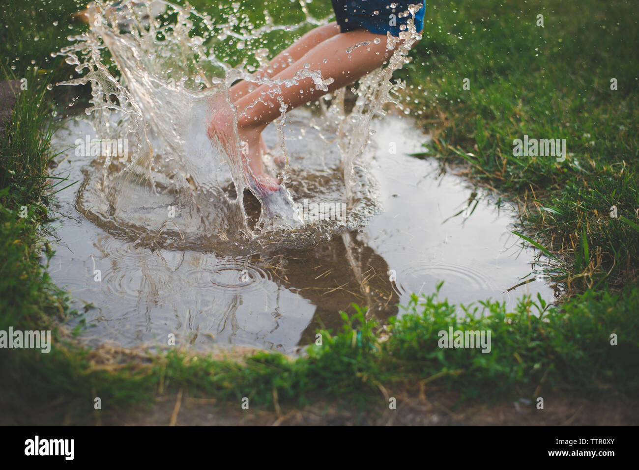 Boy jumping in puddle hi-res stock photography and images - Alamy