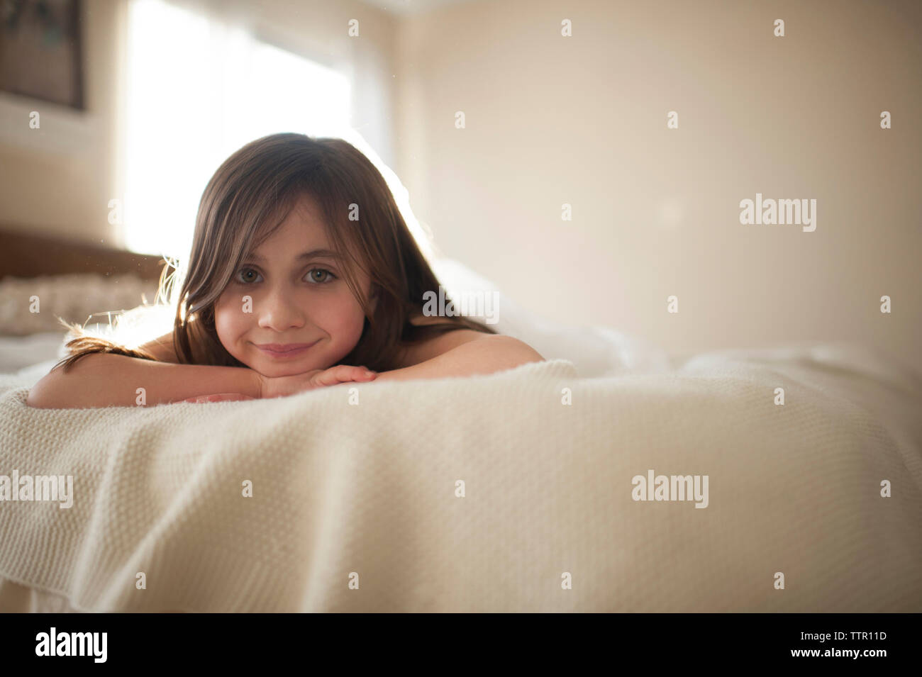 Portrait of smiling girl lying on bed at home Stock Photo - Alamy
