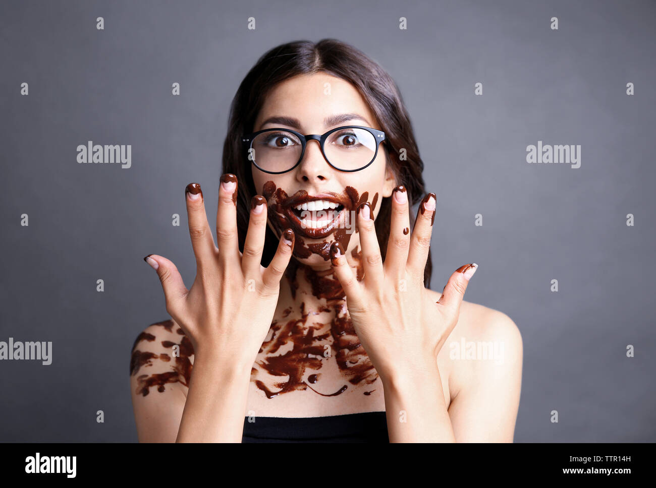 Attractive woman with smeared chocolate on grey background Stock Photo ...