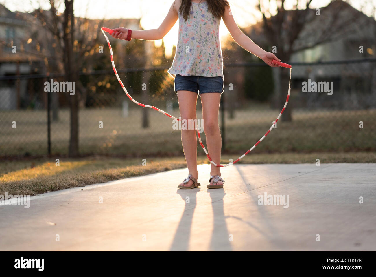 Low section of girl with jump rope at playground Stock Photo - Alamy