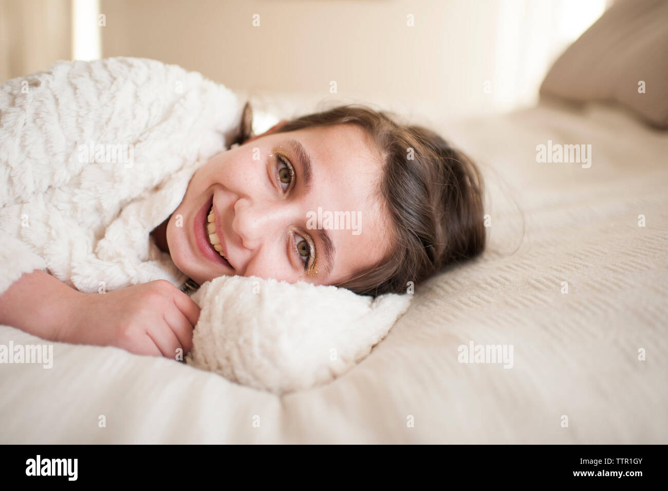 Portrait of smiling girl lying on bed at home Stock Photo - Alamy