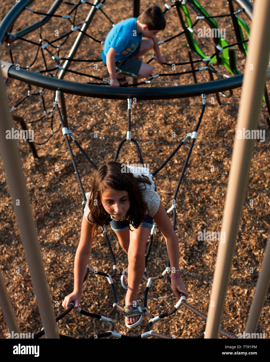 Boy and girl playing on playground equipment hi-res stock photography ...