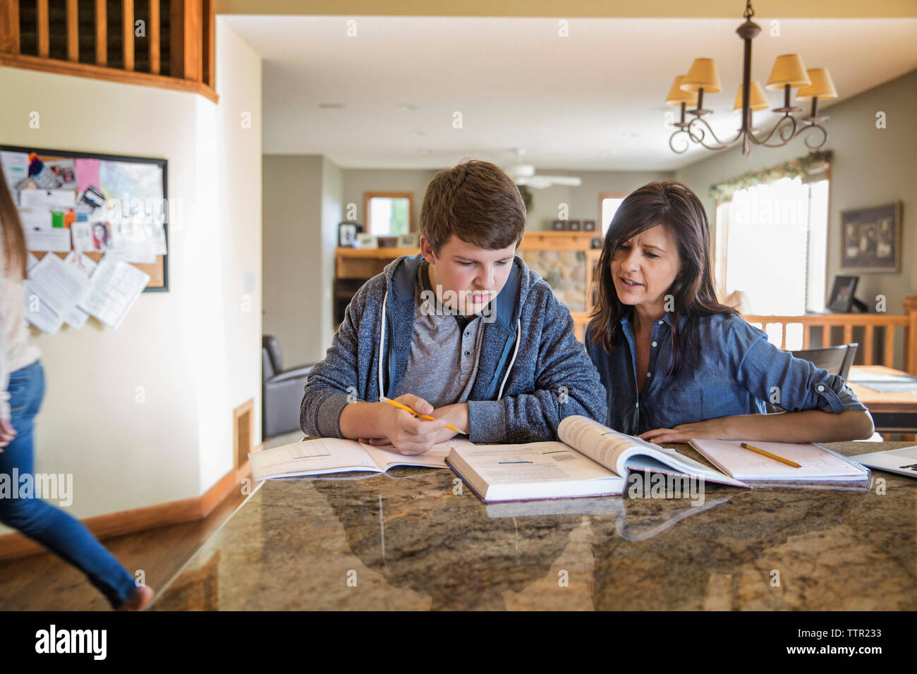 Mother teaching son on table at home Stock Photo - Alamy