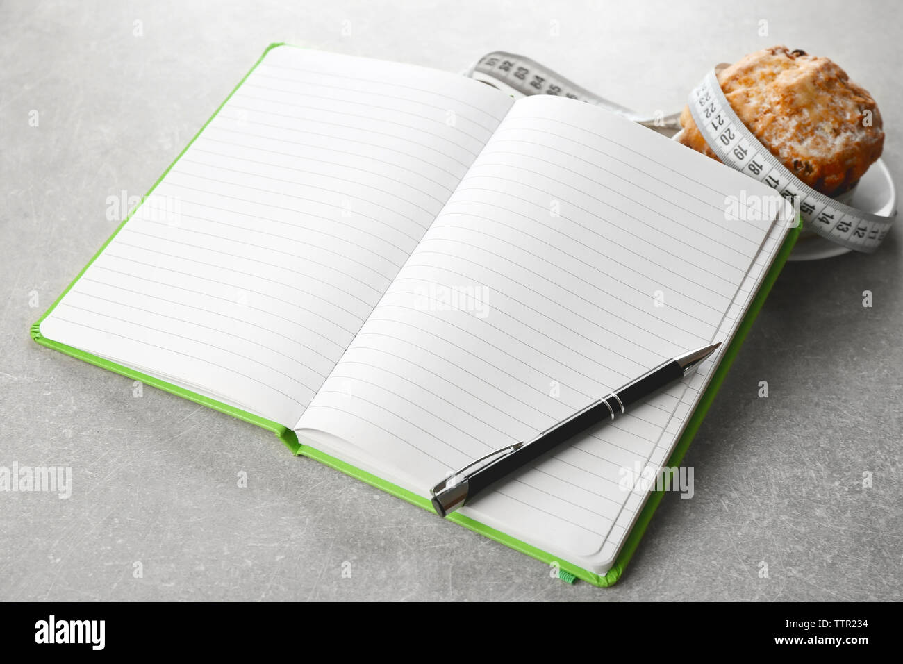 Notepad, measuring tape and cake on color background Stock Photo - Alamy