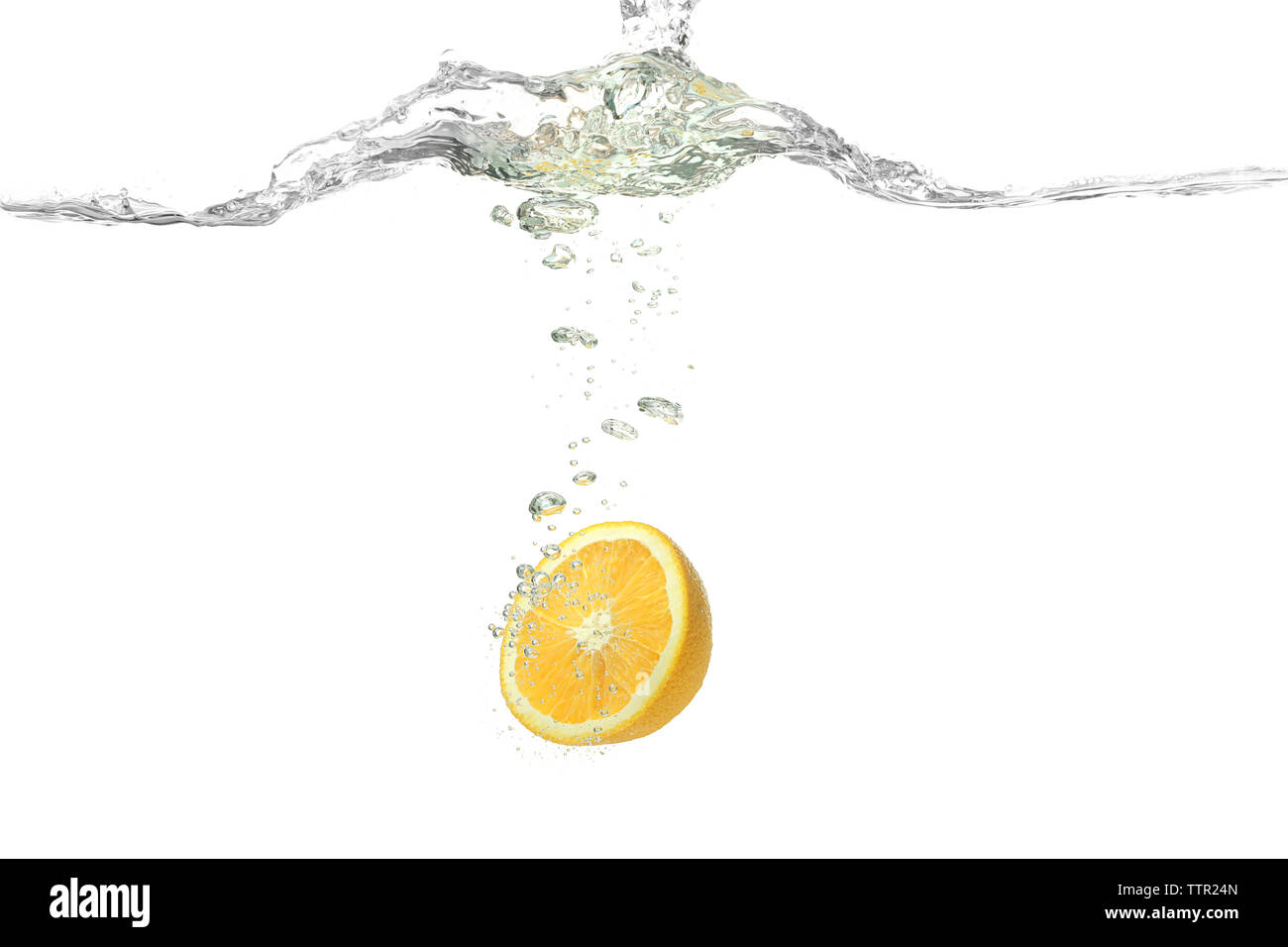 Lemon falling into water on white background Stock Photo - Alamy