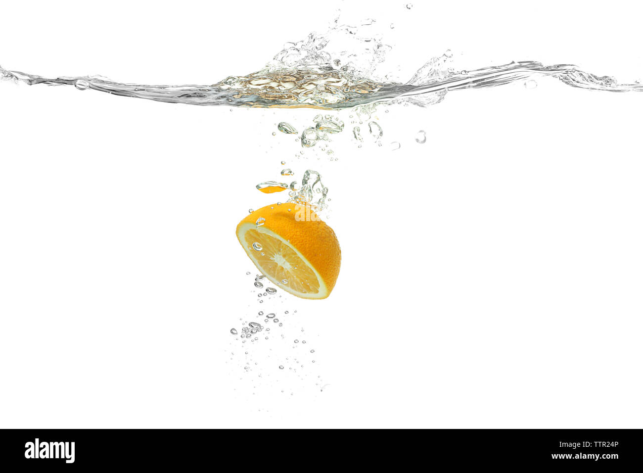 Lemon falling into water on white background Stock Photo - Alamy