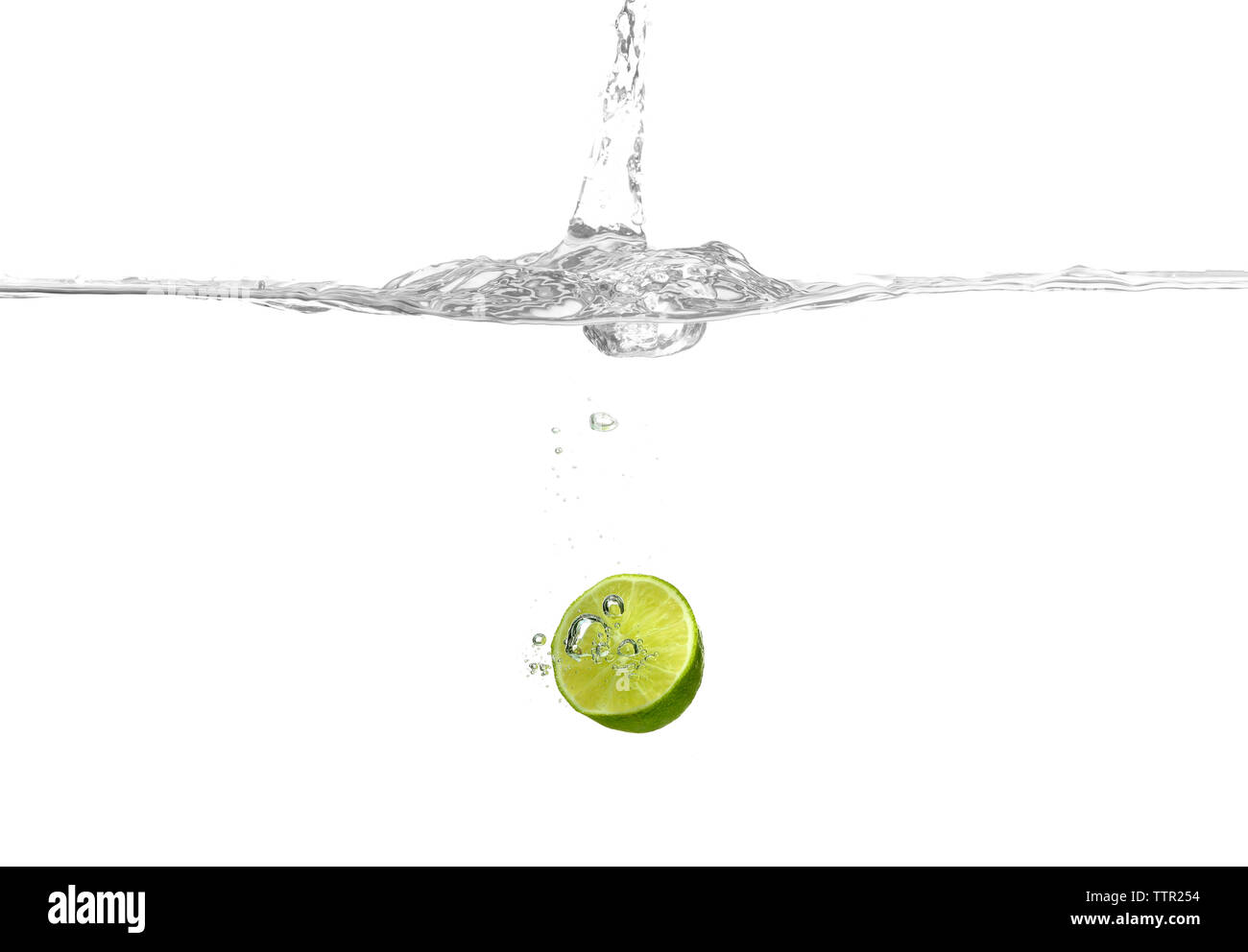 Lime falling into water on white background Stock Photo - Alamy