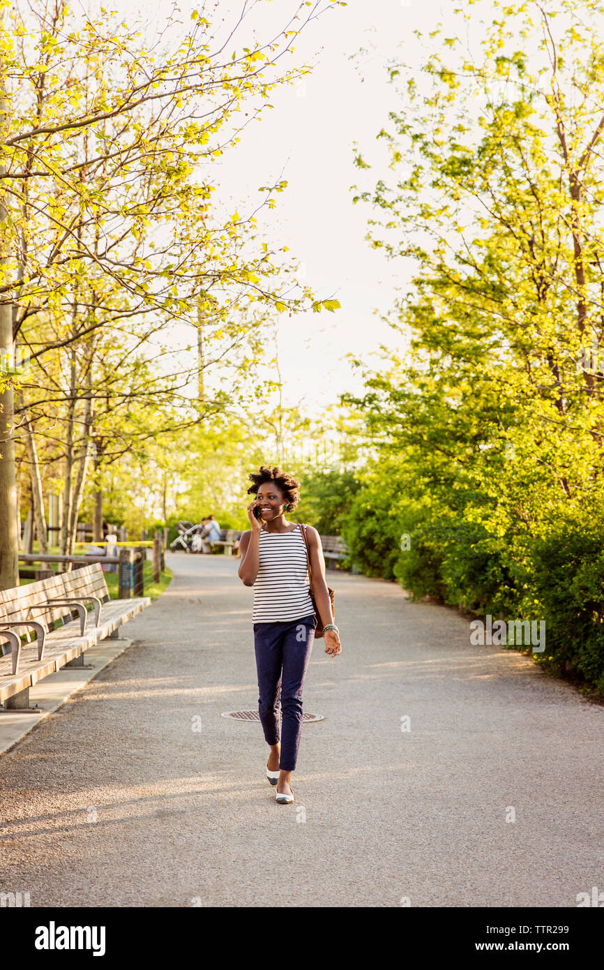 Woman walking holding mobile phone hi-res stock photography and images ...