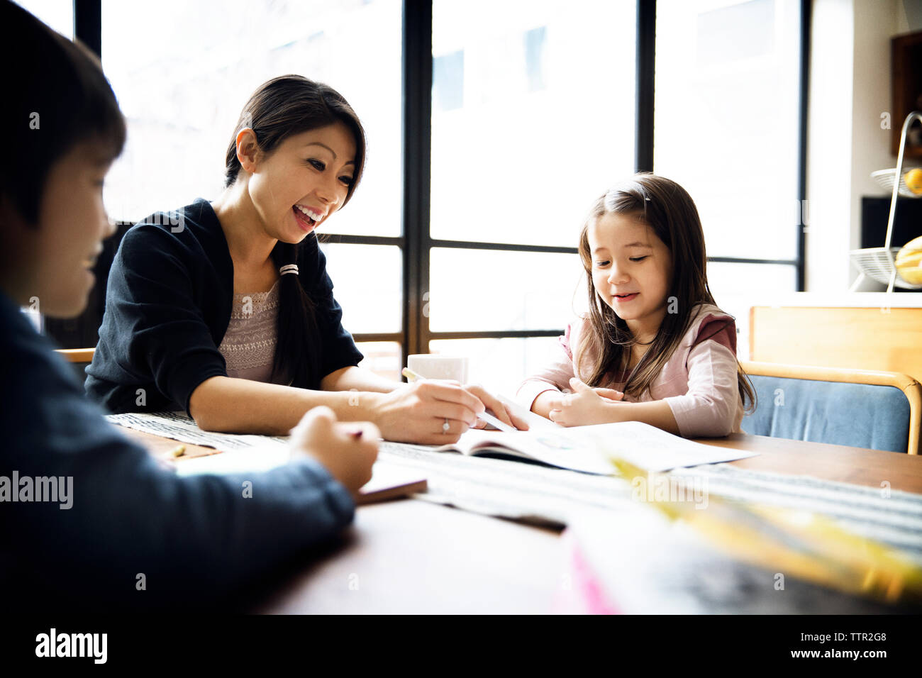 Happy mother teaching children at home on sunny day Stock Photo - Alamy