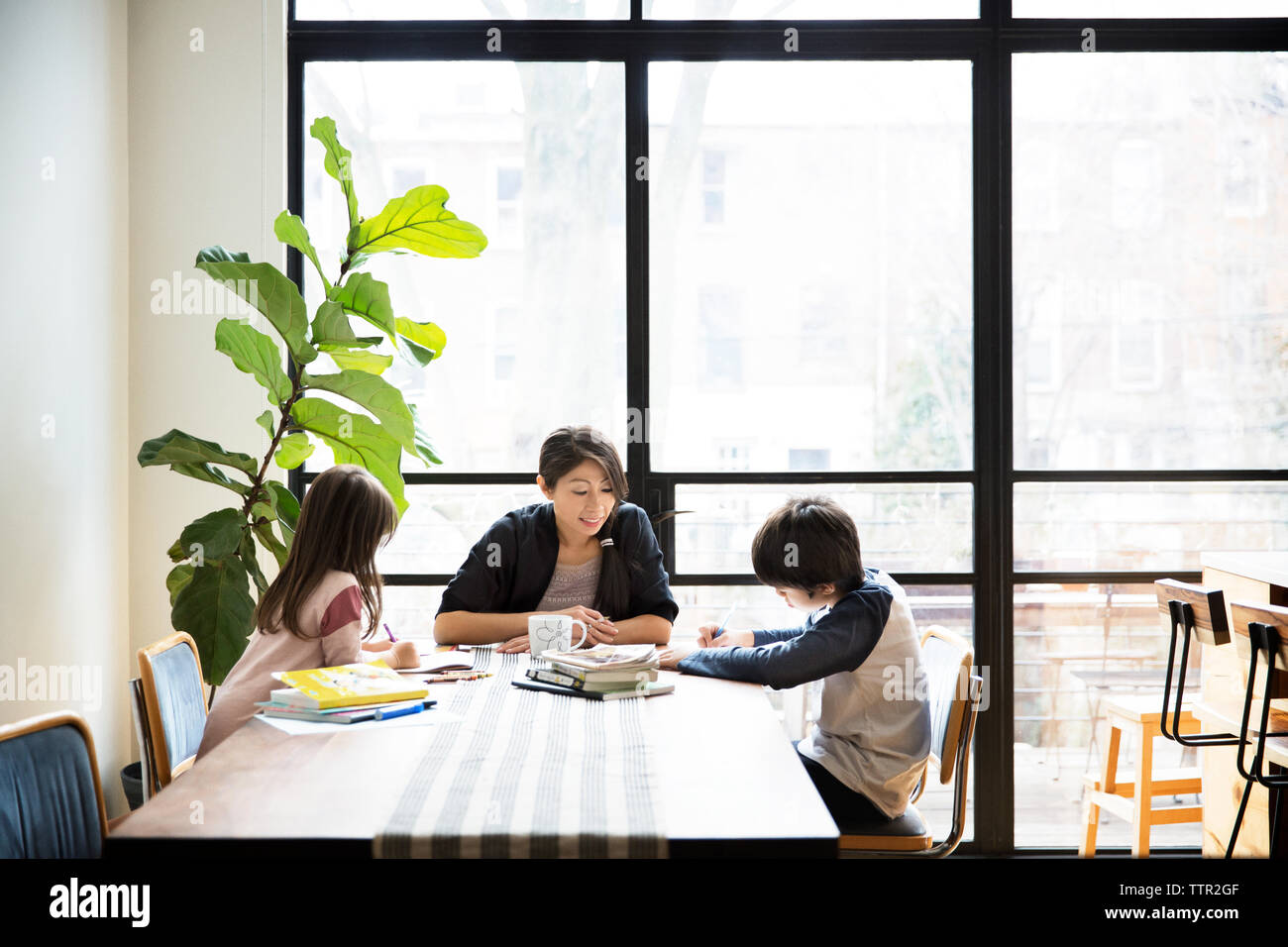 Asian woman with two children at table hi-res stock photography and ...