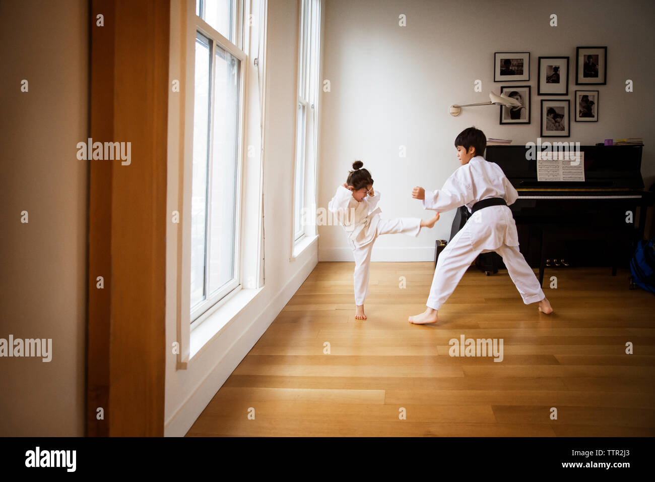 Siblings practicing karate by window at home Stock Photo - Alamy