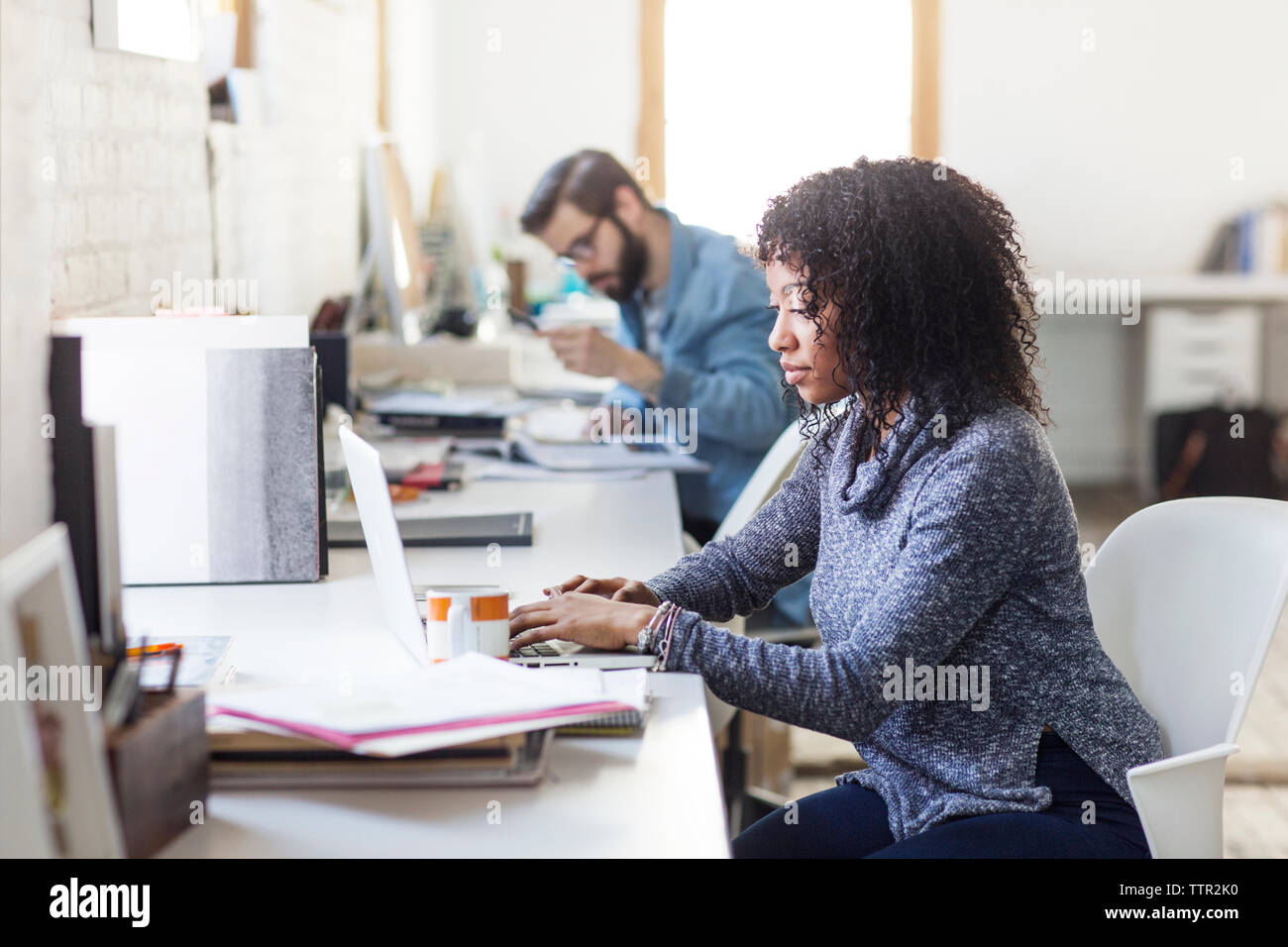 Serious business people working at desk in creative office Stock Photo ...