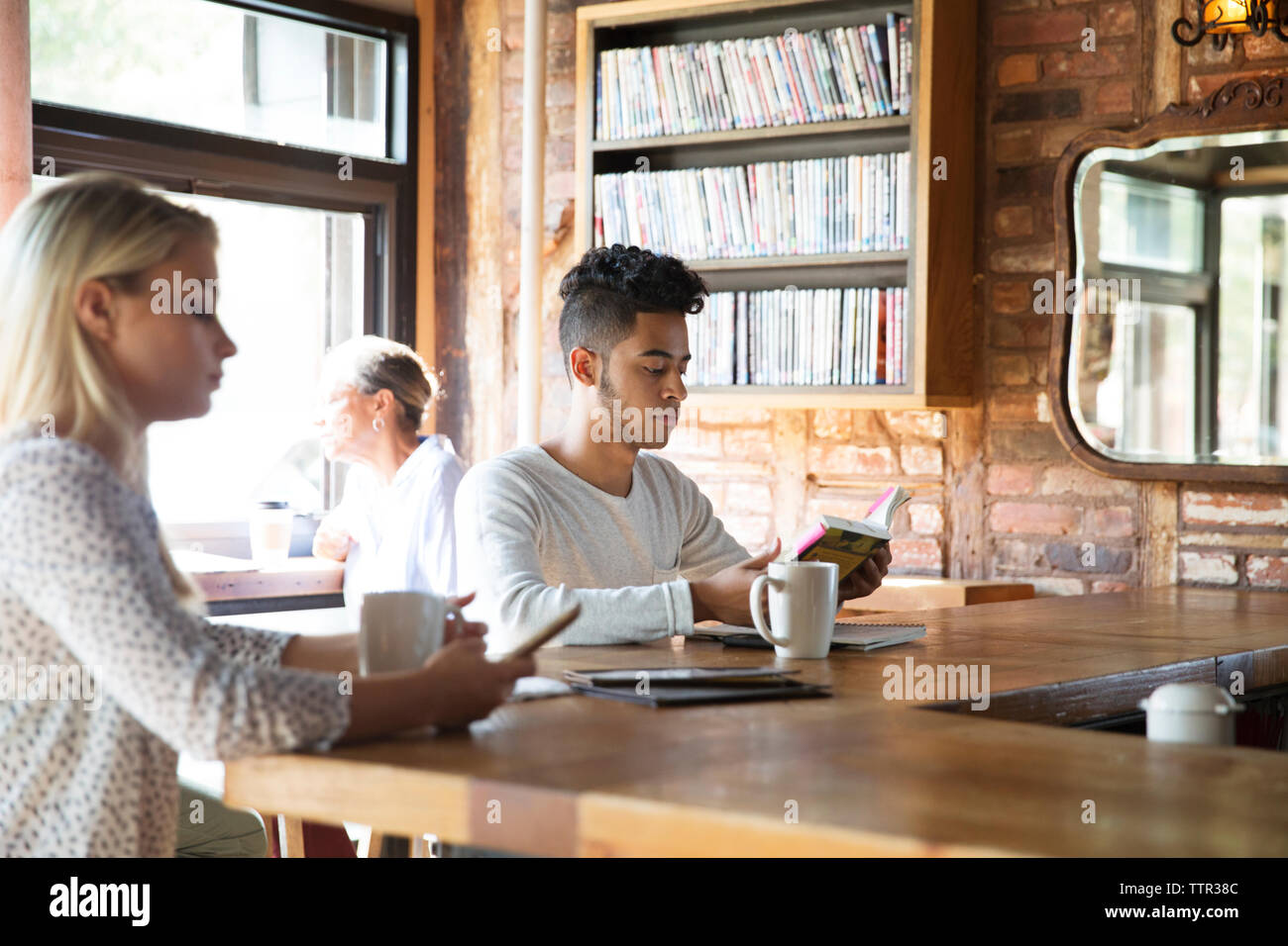 People resting while having coffee at bar counter in cafe Stock Photo ...