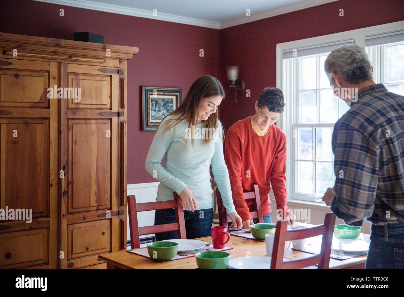 Smiling family setting table at home Stock Photo - Alamy