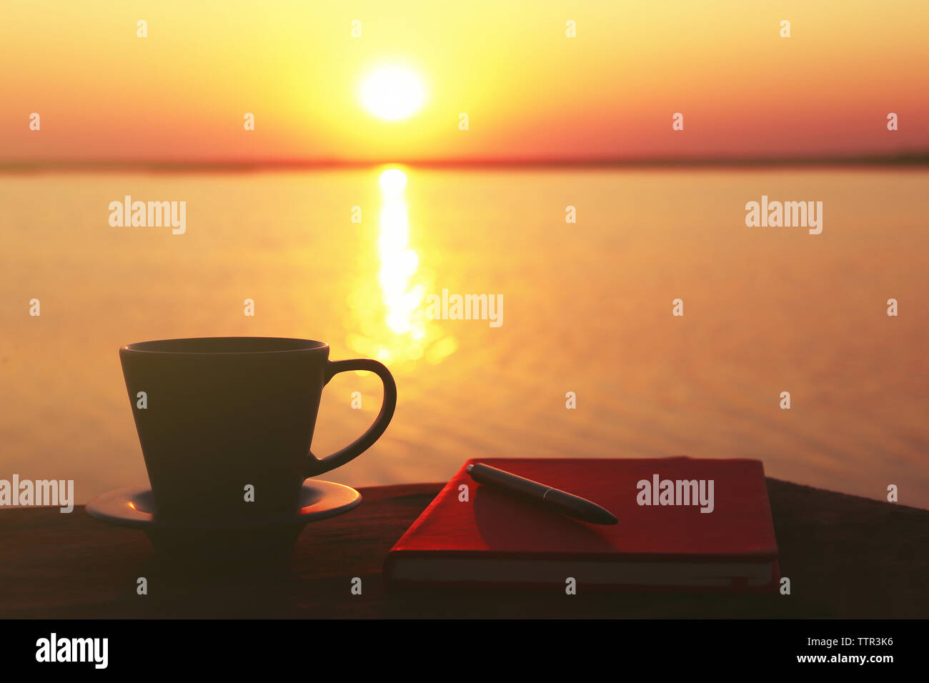 Cup of coffee on sunset background Stock Photo - Alamy
