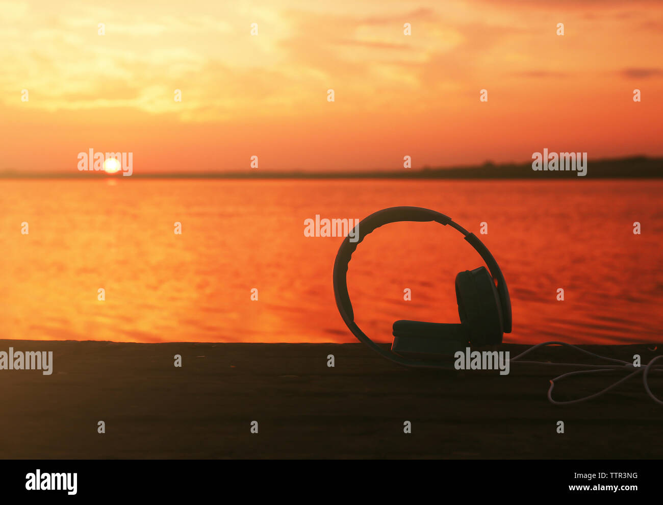 Headphones on sunset sky background Stock Photo - Alamy