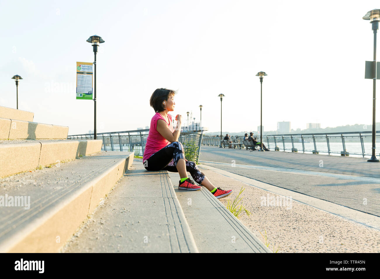 Thoughtful woman resting while sitting on steps Stock Photo - Alamy